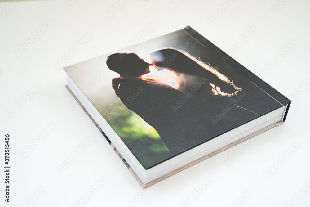 closed wedding photobook with thick pages on a white table. convenient ...