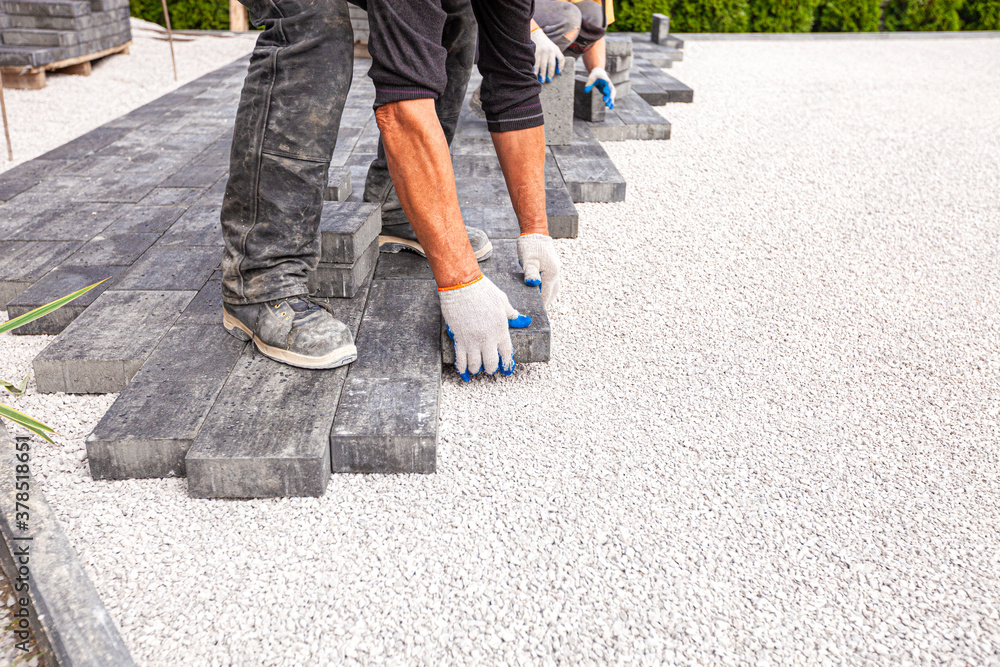 Paver is laying paving stones. Laying concrete paving stones. Stock ...