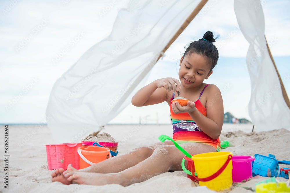 cute little girl playing on the beach on summer holidays. Happy child ...