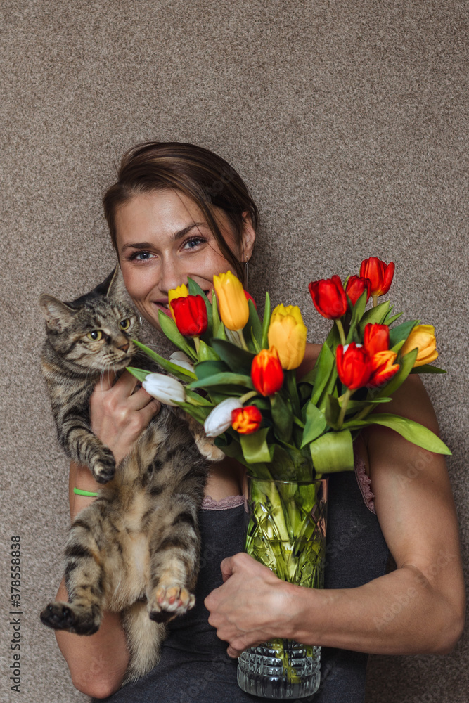 Russian girl with a cat and a vase with tulips in her hands Stock Photo ...