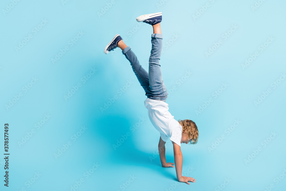 Full length photo of little kid stand hands raise legs wear white shirt ...