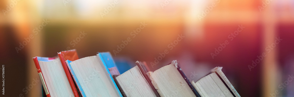 Book stack in the library and blurred bookshelf background for ...