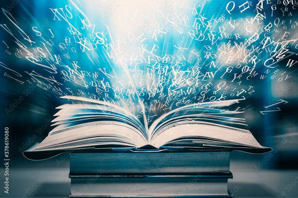 Open book on the table and english alphabet floating above the book in ...
