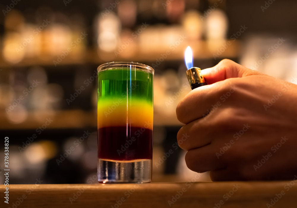 Beautiful tricolor cocktail. Red green yellow alcoholic drink standing ...