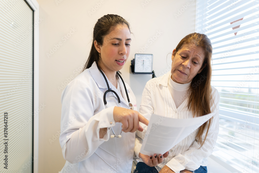 Young latin female doctor with papers explaining exam results to ...