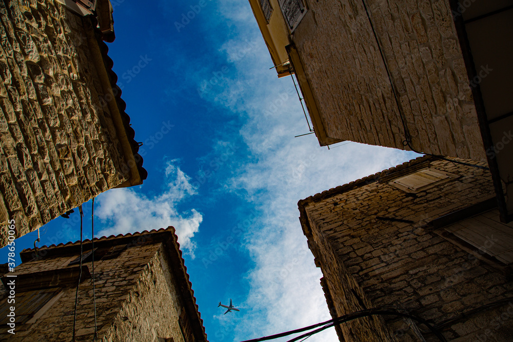 Corner detail and cornices and plane over blue sky with clouds Stock ...