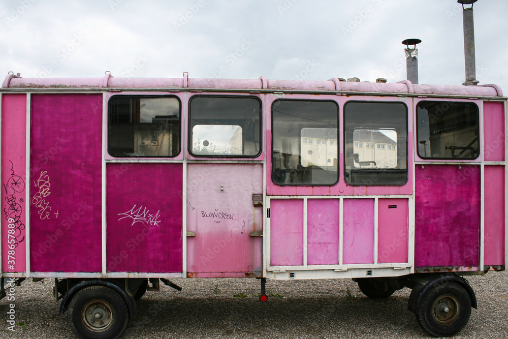 An old, broken-down caravan truck, with its panels painted several ...
