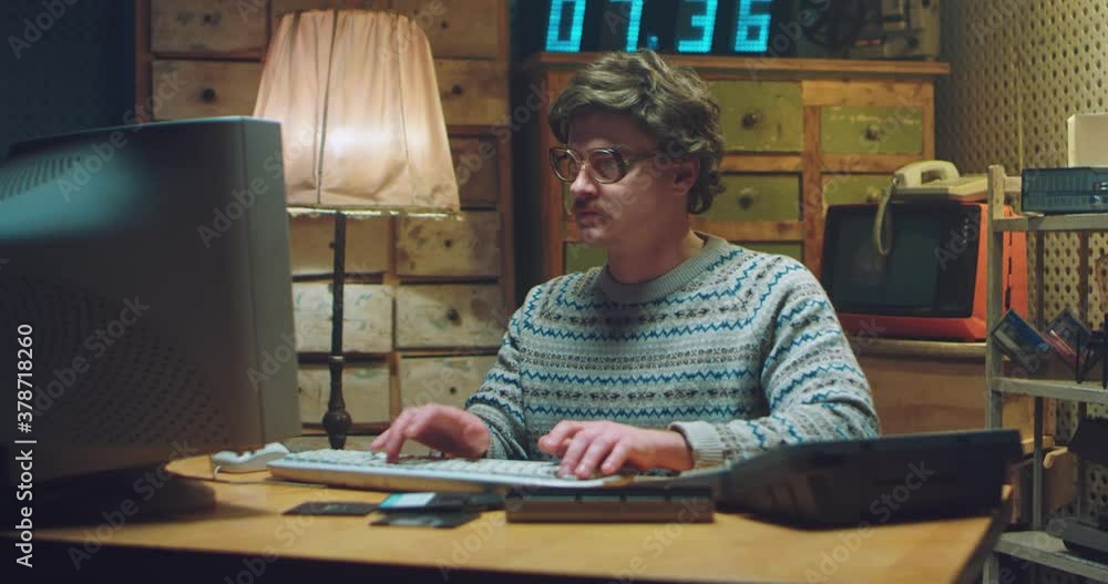 Caucasian male nerd in glasses with mustache sitting at desk in retro ...