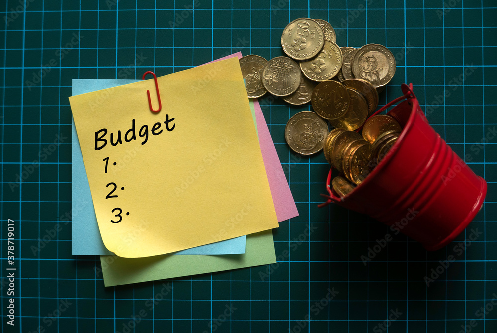 Top view of gold coins and a stack of memo notes written with Budget ...