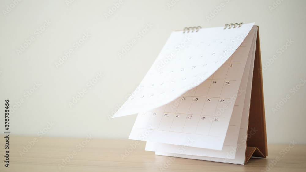 Calendar page flipping sheet on wood table background business schedule ...