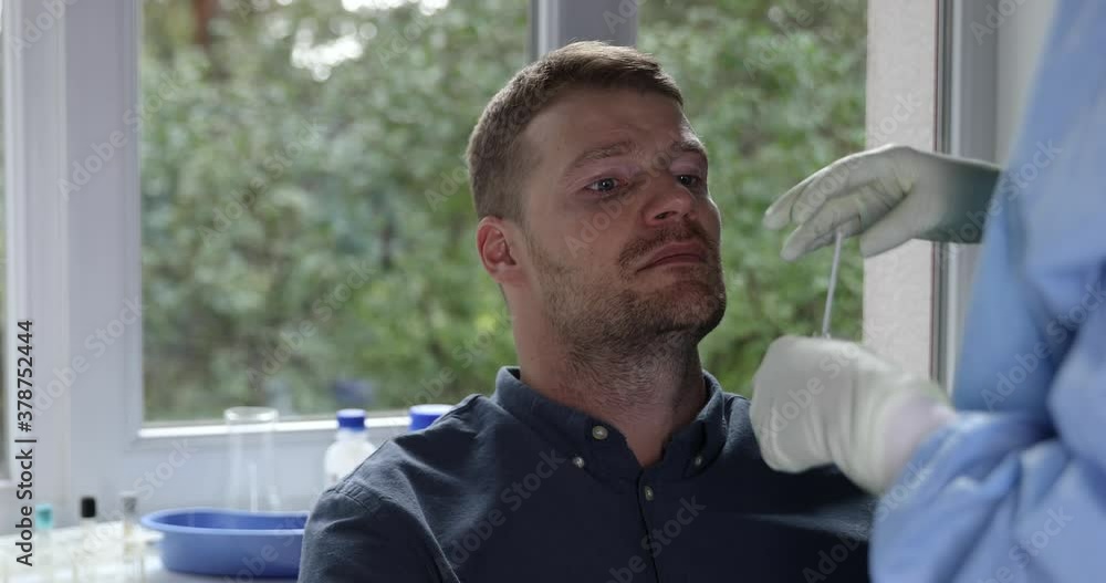 covid-19 nasal swab test - doctor taking a mucus sample from male ...