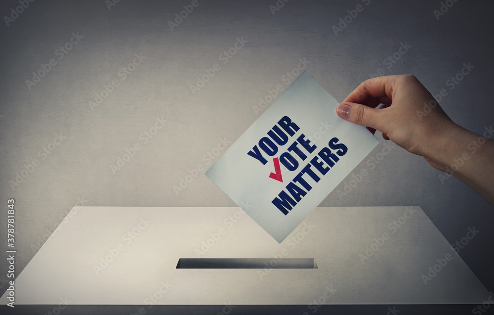 Person at the polling station holding a ballot paper in his hand with ...