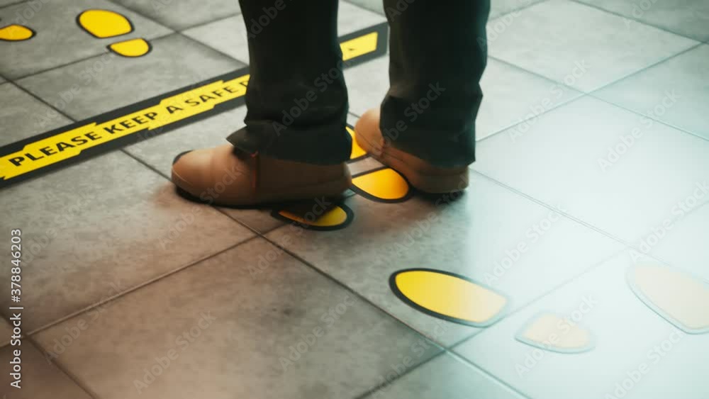 Social distancing floor signs during the coronavirus pandemic.Yellow ...