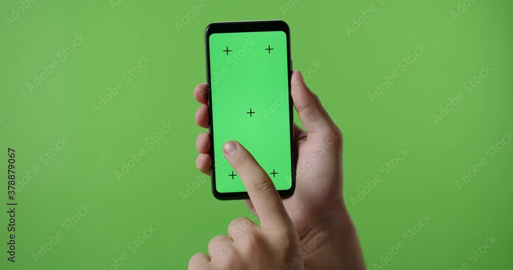 Close up of man's hand holding a smart phone with vertical green mock ...