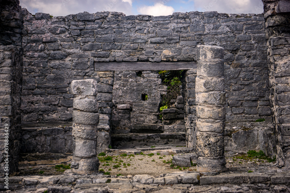 Stone walls and pillars still remain of the ancient Mayan ruins of ...