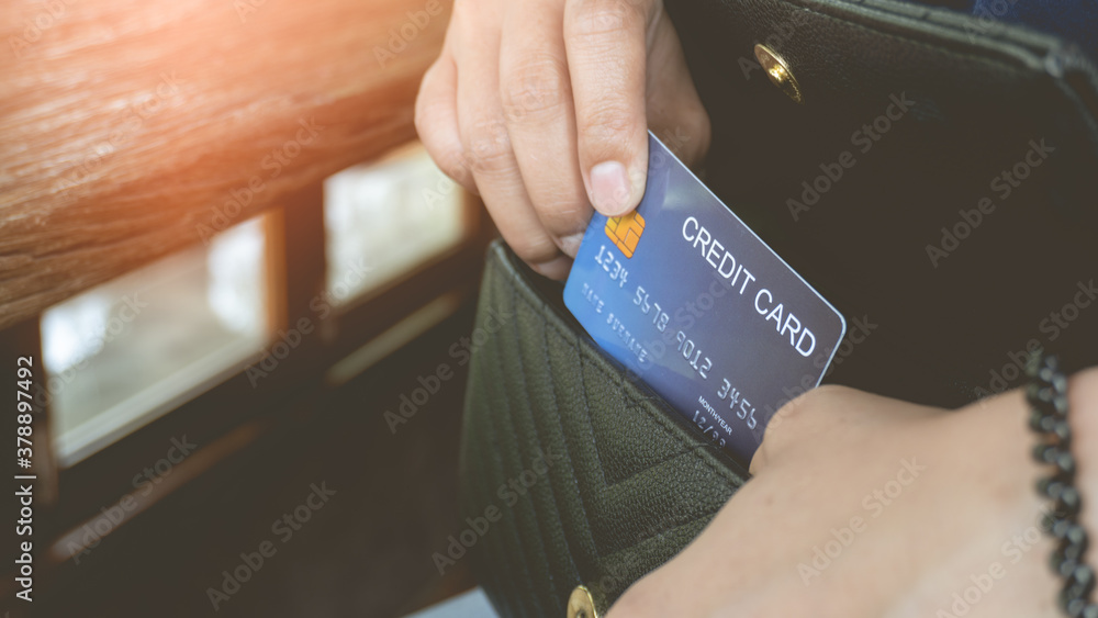 Woman hands grab a blue credit card from her black wallet for shopping ...
