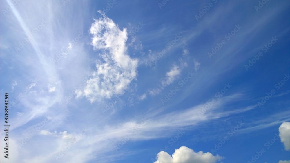 Blue sky with blurry white and fluffy floating clouds. Shades of color ...