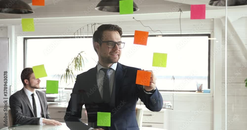 Smiling young thoughtful confident manager in formal suit and eyewear ...