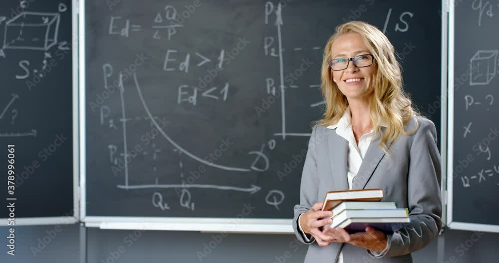 Portrait of beautiful Caucasian woman teacher standing in classroom at ...