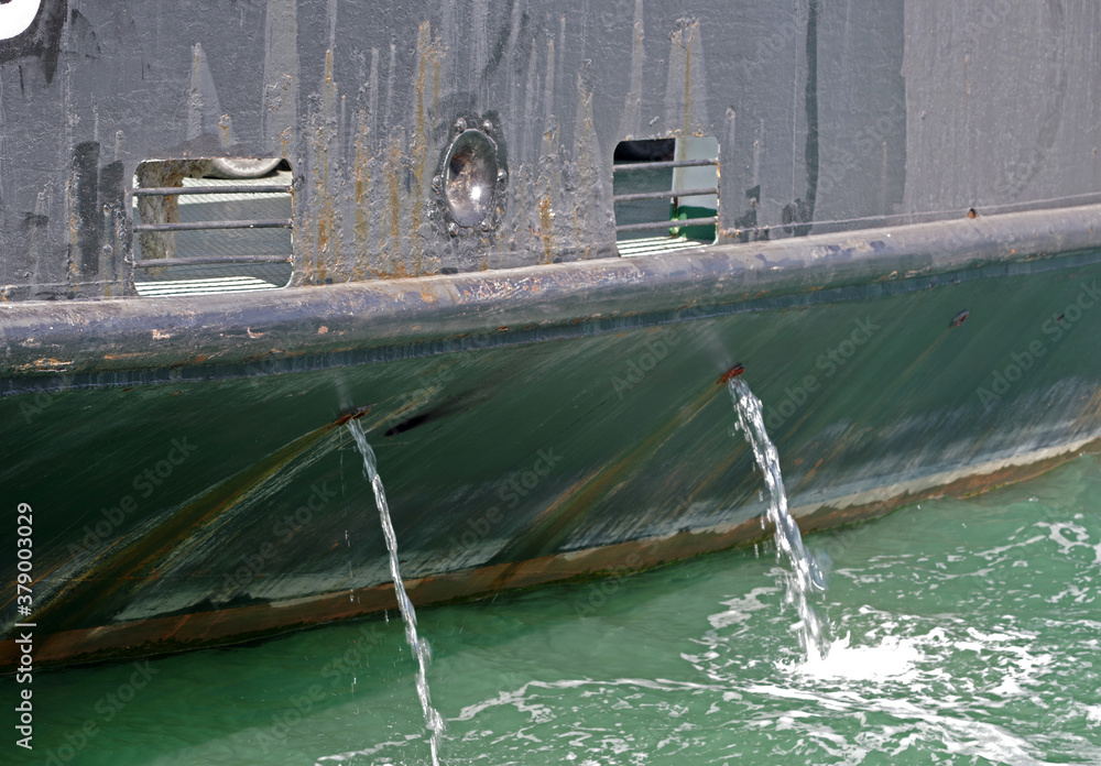 Water flows from the tube on the hull of ship Stock Photo | Adobe Stock
