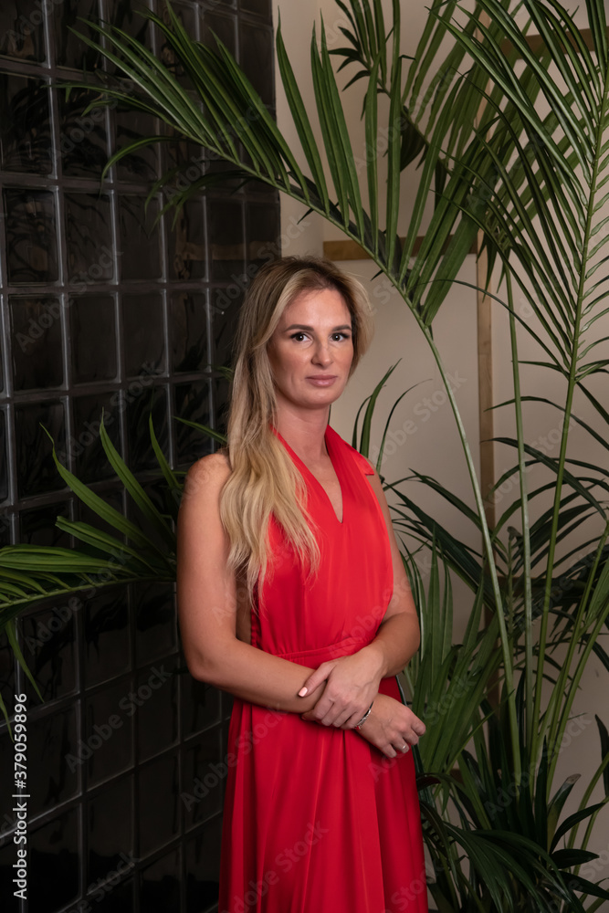 Portrait Of Beautiful Middle Aged Caucasian Woman In Red Dress Standing
