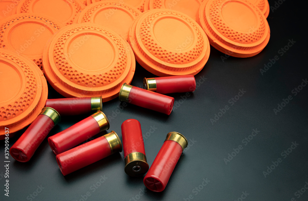 Clay disc flying targets and shotgun bullets on black background ,Clay ...