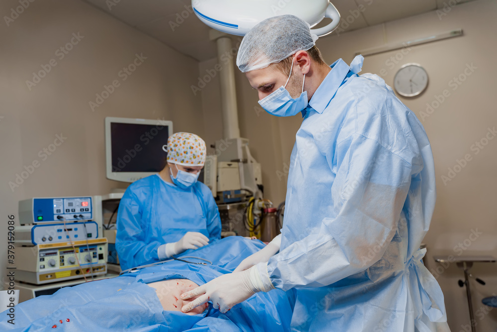 Liposuction for lipofilling surgery operation. 2 surgeon do plastic ...