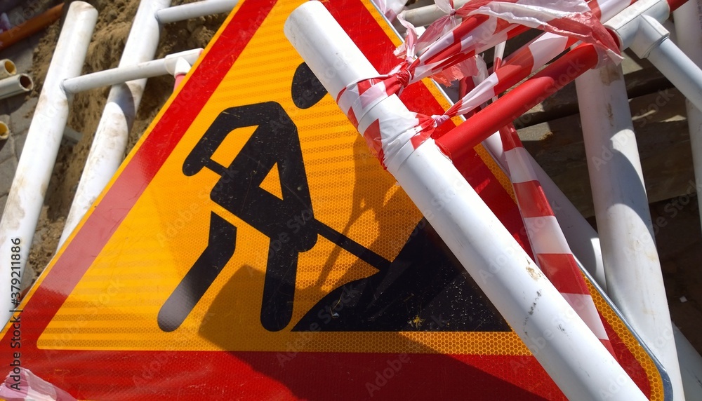 Road works sign denoting construction work and metal fencing on the ...