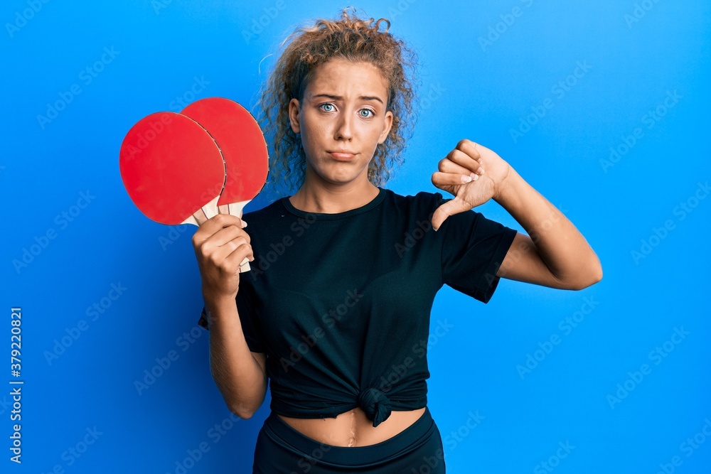 Beautiful caucasian teenager girl holding red ping pong rackets with ...