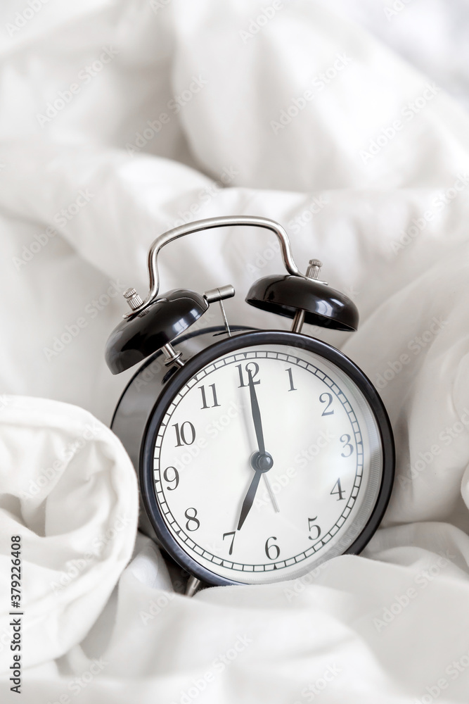 Classic alarm clock in bed, concept of morning routine, wake up call ...