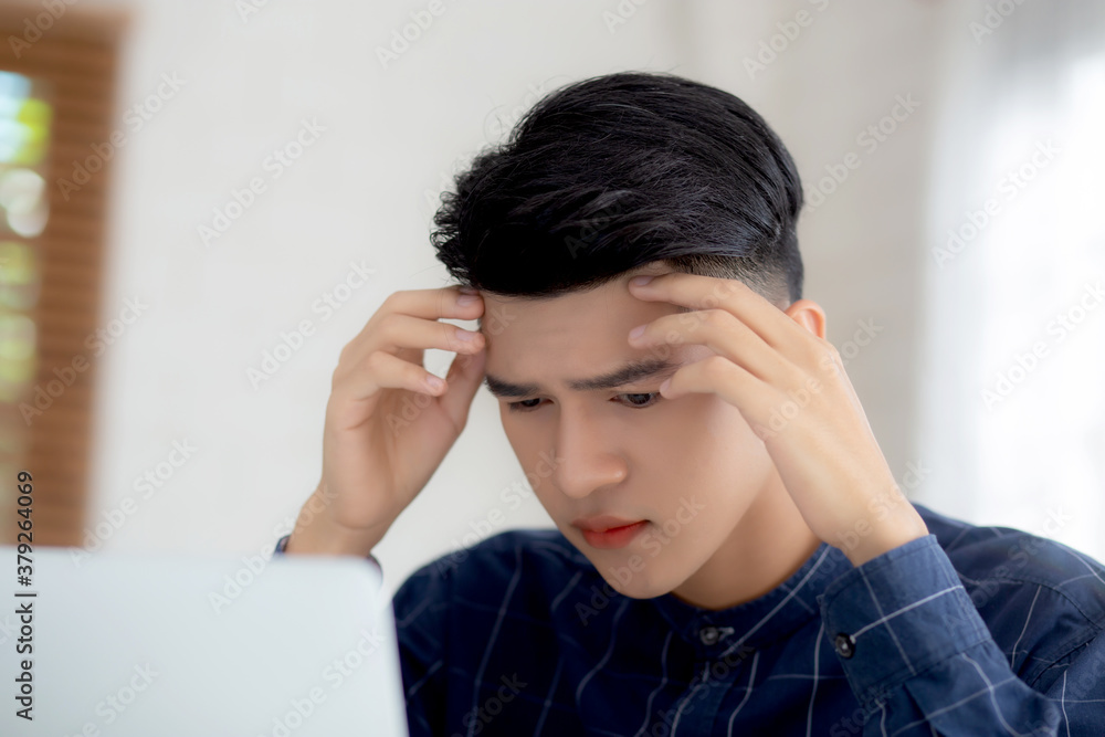 Young asian business man headache during working on laptop computer ...