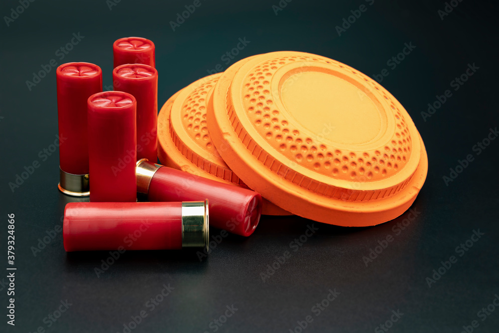 Clay disc flying targets and shotgun bullets on black background ,Clay ...