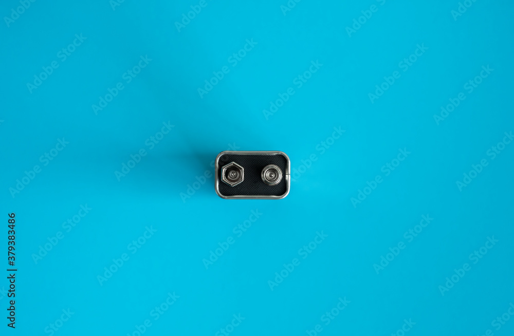 High voltage battery on a blue background. Silver Volt battery. 9V ...
