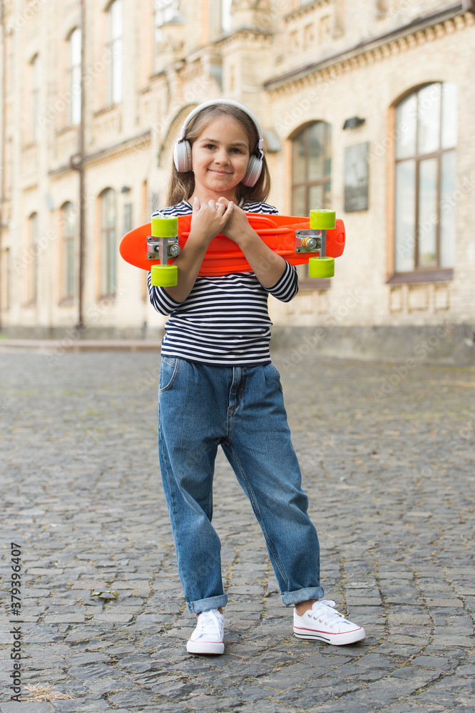New adventure awaits. Happy kid hold penny board outdoors. Aboveground ...