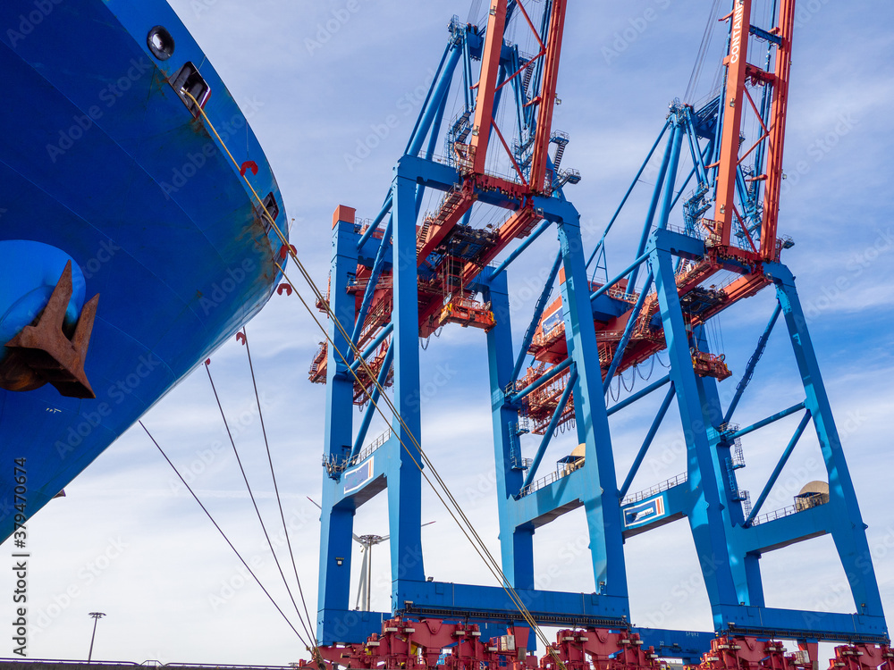next to a container ship there are large container cranes for loading ...