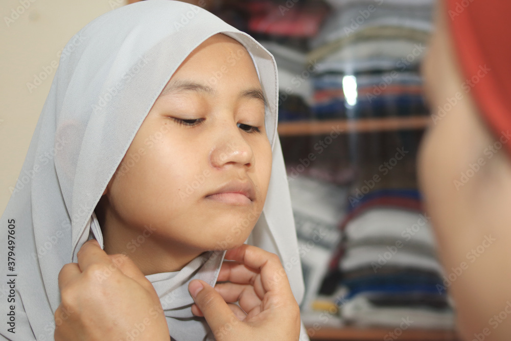 Muslim girl wearing hijab with the help of her mother, islam religion ...
