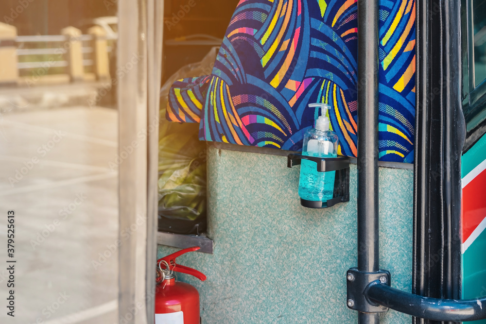 Blue alcohol gel bottle hanging on the door of the double-decker bus to ...
