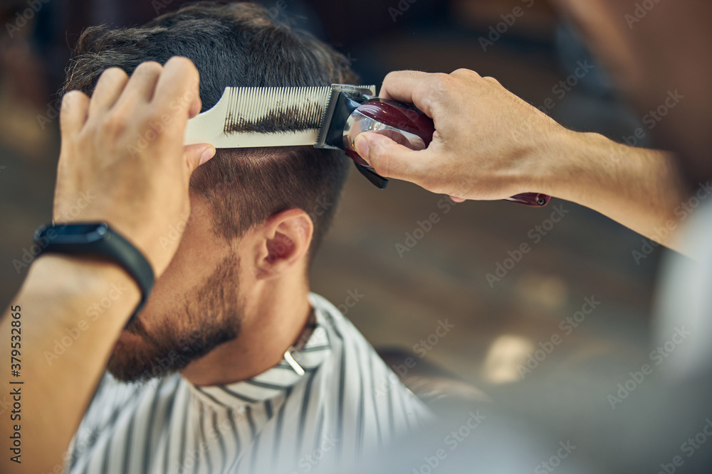 Skillful hair-stylist using electric hair clipper to cut hair Stock ...