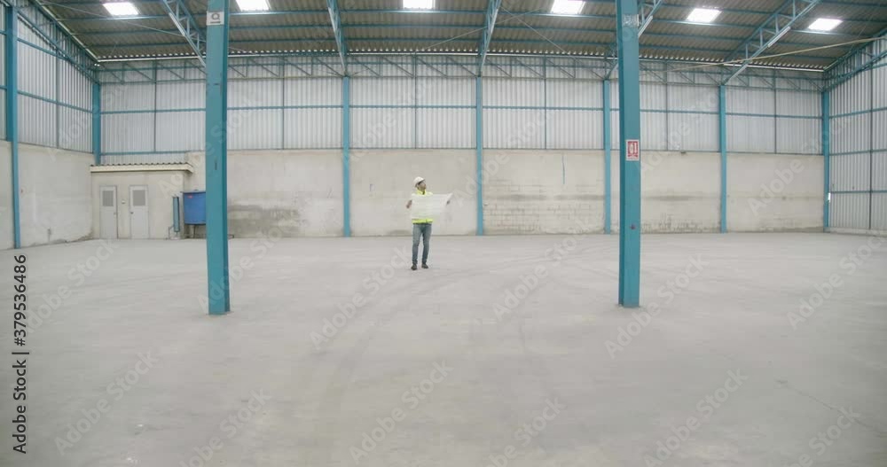 An engineer wearing high visibility vest and hard hat holding the ...