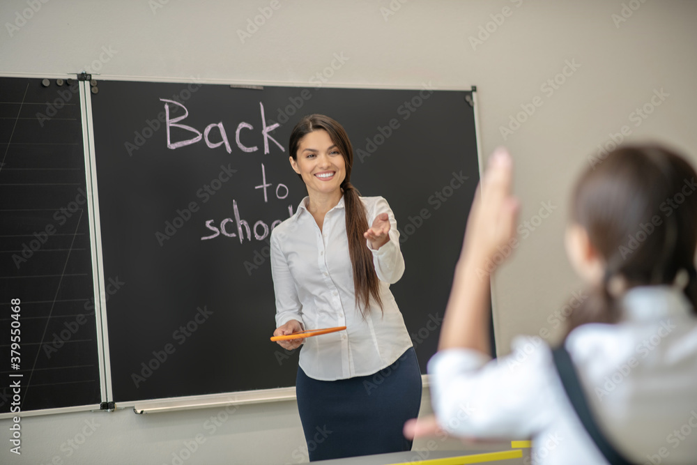 Cute teacher asking her pupil about new marerial Stock Photo | Adobe Stock