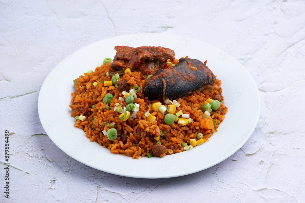 Jollof rice with stewed goat meat and vegetables Stock Photo | Adobe Stock