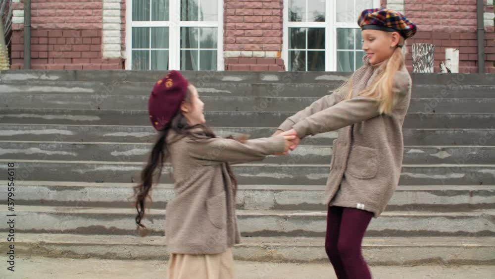 Playful teen girls holding hands whirling on staircase countryside ...