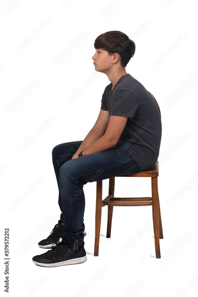 teenage boy sitting on a chair with white background,look side Stock ...