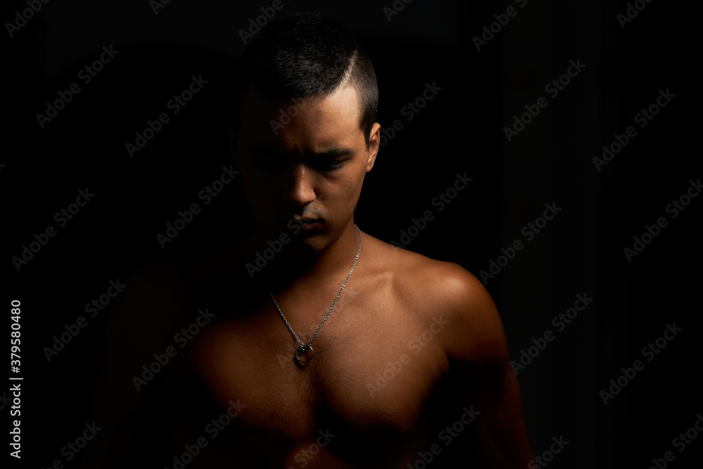 muscular young guy looking down. Muscular teenager shirtless on black ...