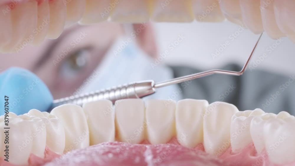 Dentist in blue medical gloves and protective mask inspects patient's ...