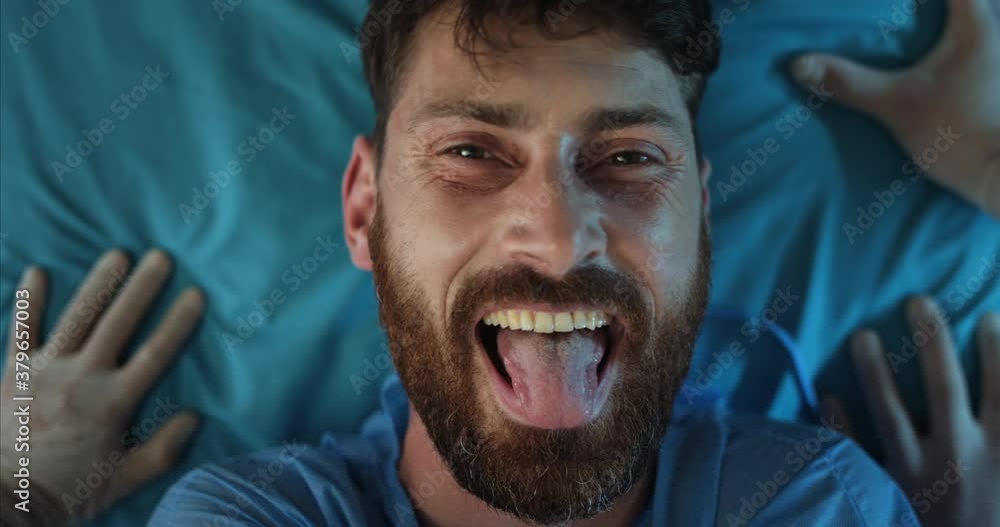 Top view of bearded man on drugs lying on medical transportation cart ...