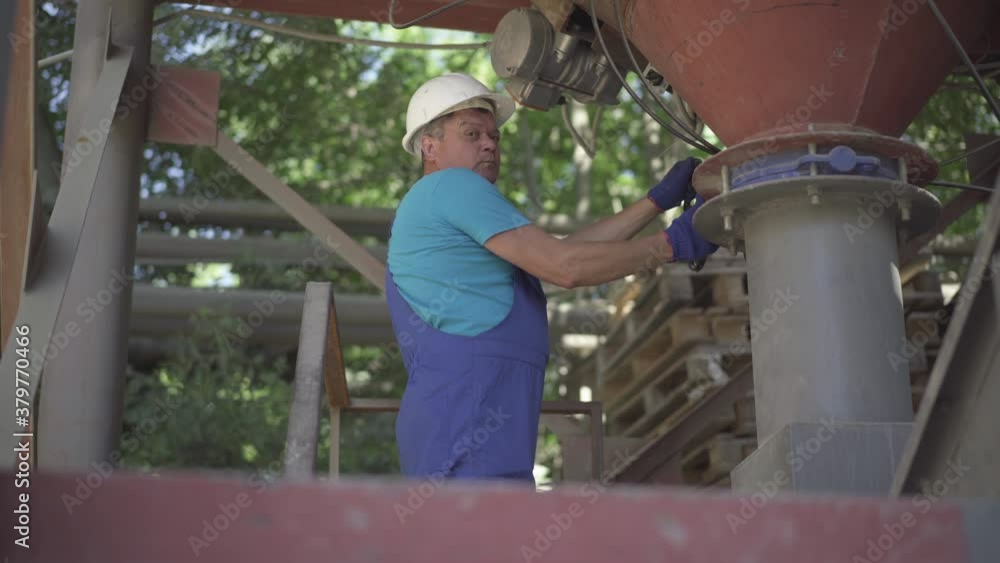 Caucasian man in uniform walking up the ladder and turning wheel on ...