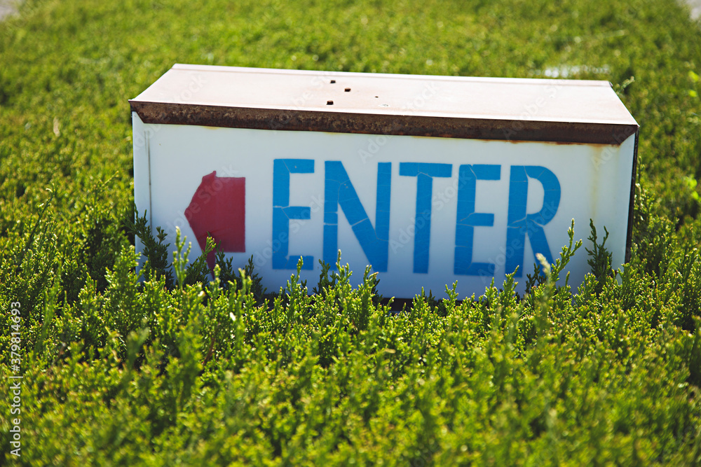 Enter sign with red arrow in shrub / bushes Stock Photo | Adobe Stock