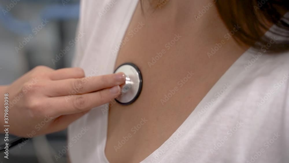 Close-up of doctor hand using stethoscope with a female patient ...