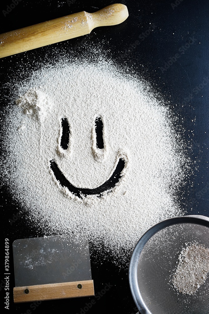 Smiley face drawn in a floured work surface. foto de Stock | Adobe Stock